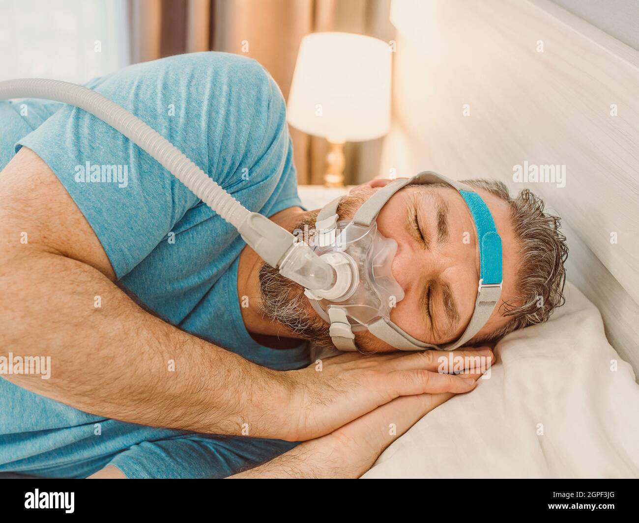 Sleeping man with chronic breathing issues considers using CPAP machine ...