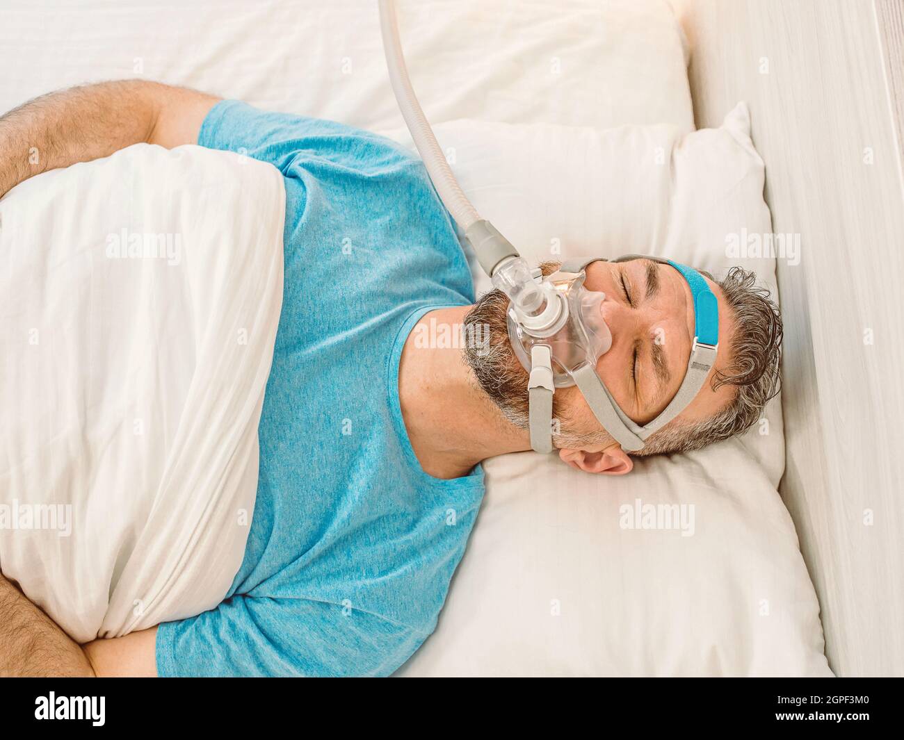 Sleeping man with chronic breathing issues considers using CPAP machine ...
