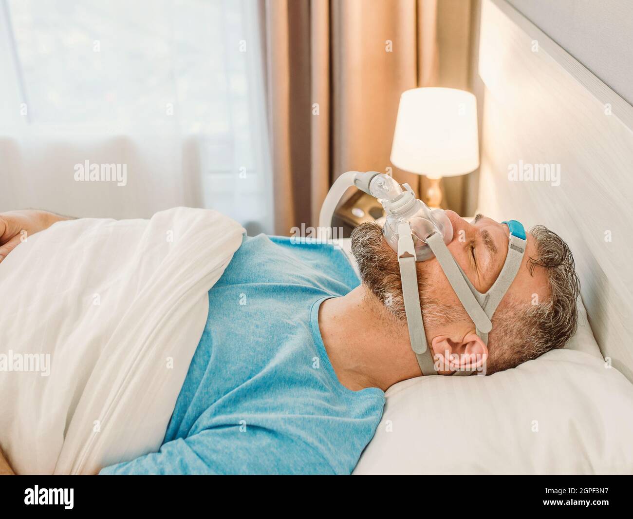 Sleeping man with chronic breathing issues considers using CPAP machine ...