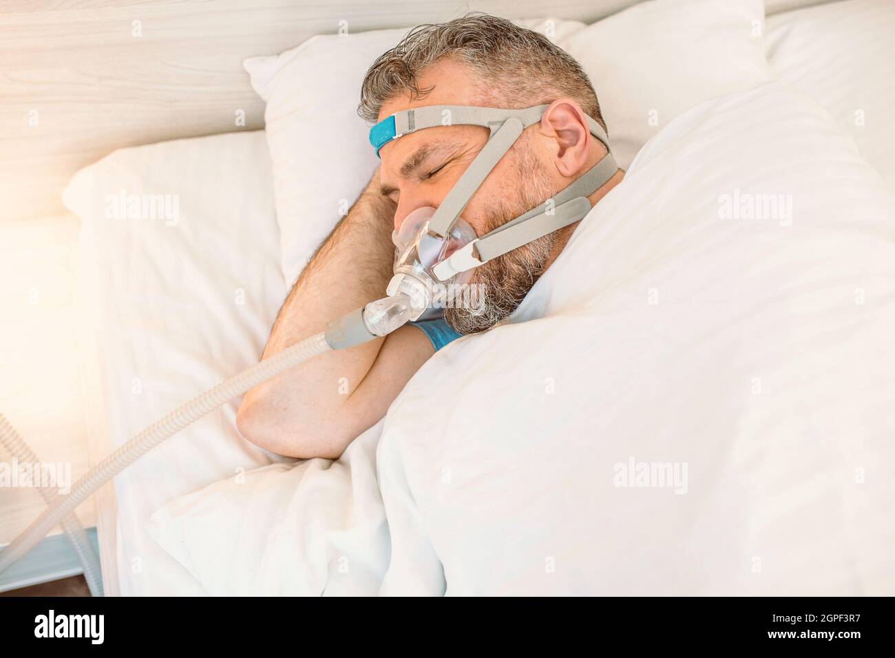 Sleeping man with chronic breathing issues considers using CPAP machine ...