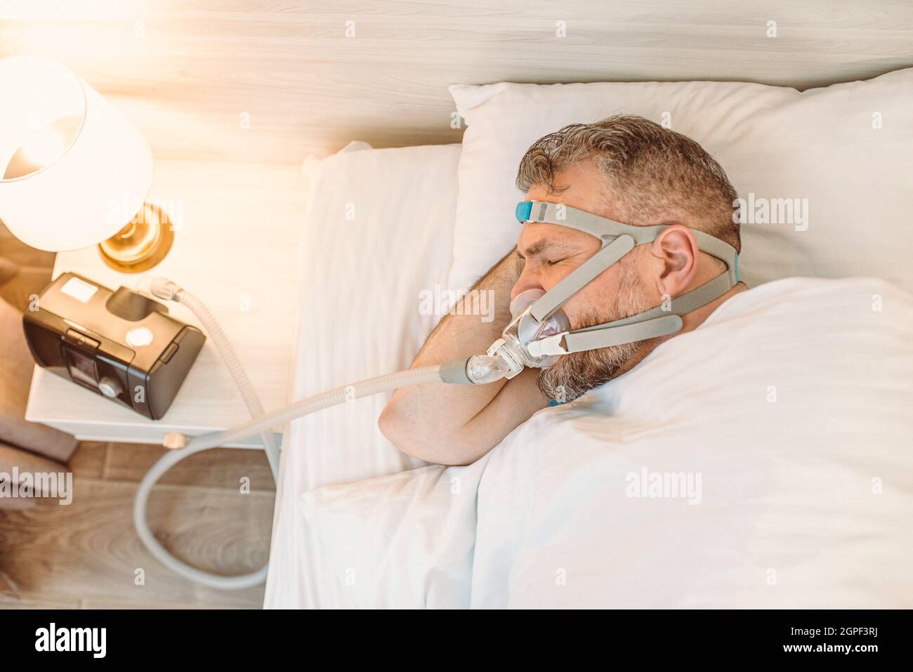 Sleeping man with chronic breathing issues considers using CPAP machine ...