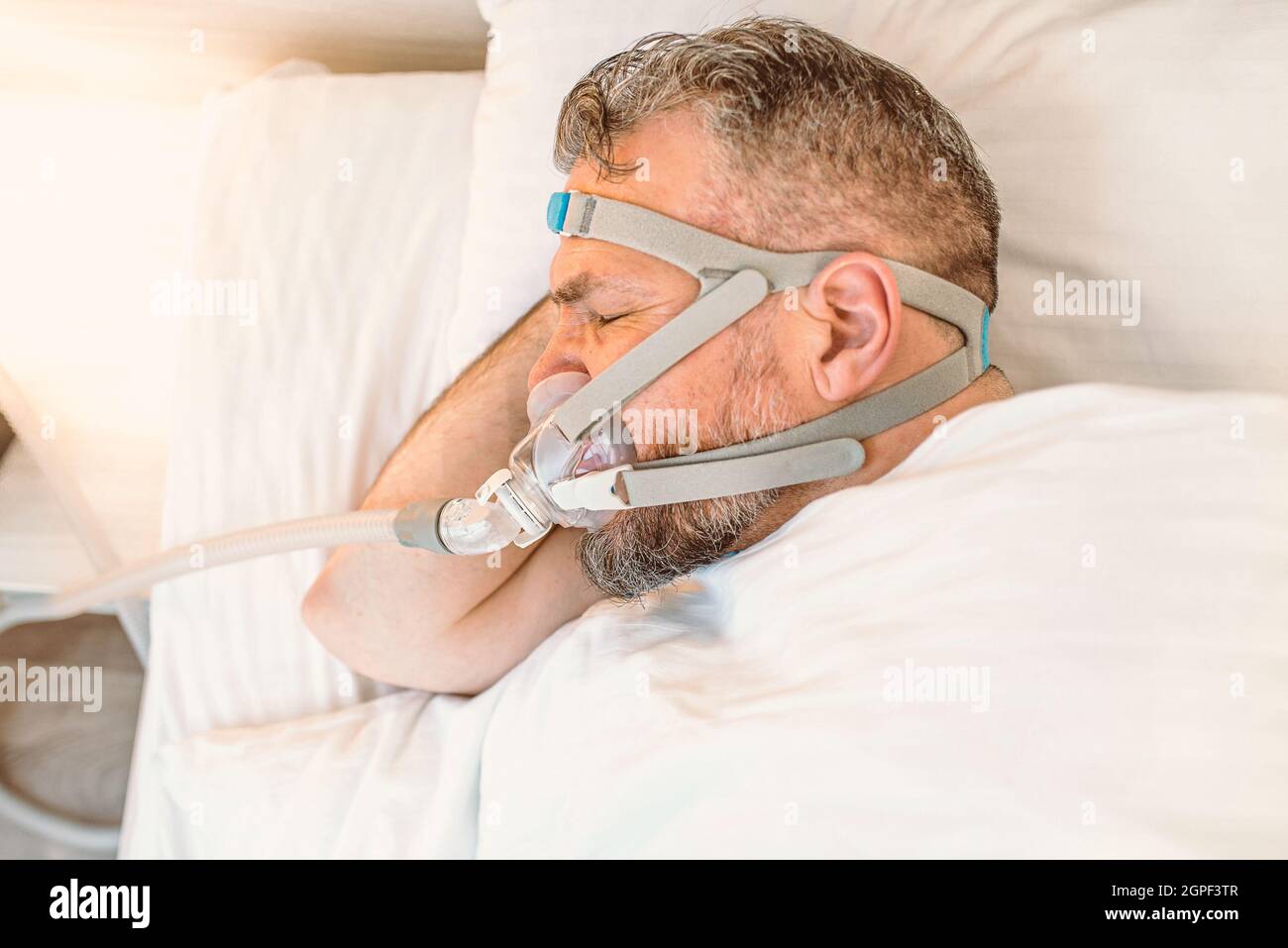 Sleeping man with chronic breathing issues considers using CPAP machine ...