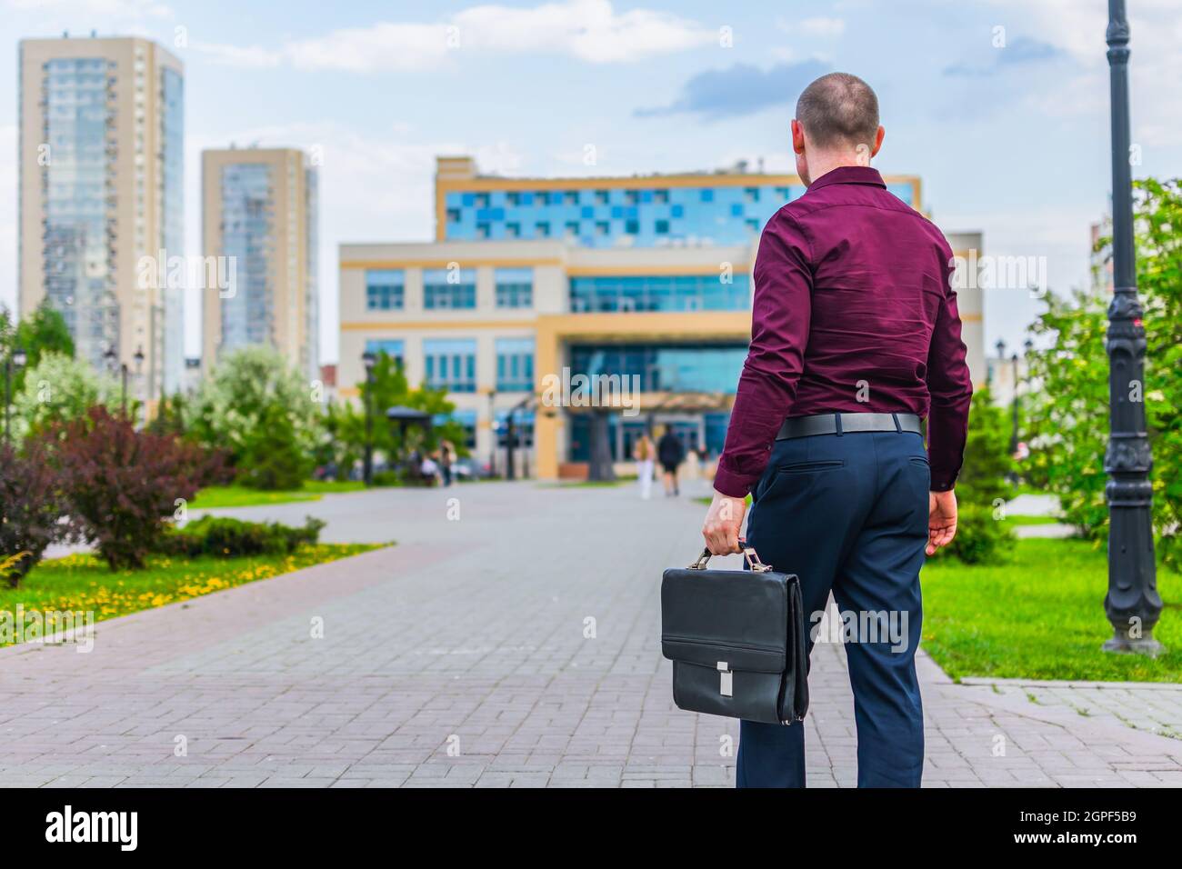 Businessman with a briefcase in hand goes to his work in an office ...