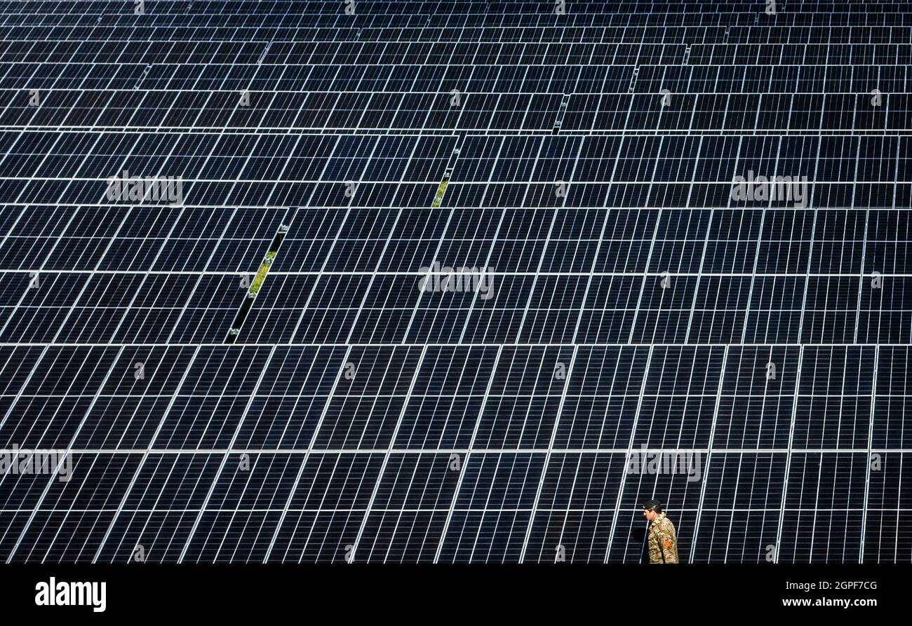 Major David Owen walks through a field of solar panels at the opening ...