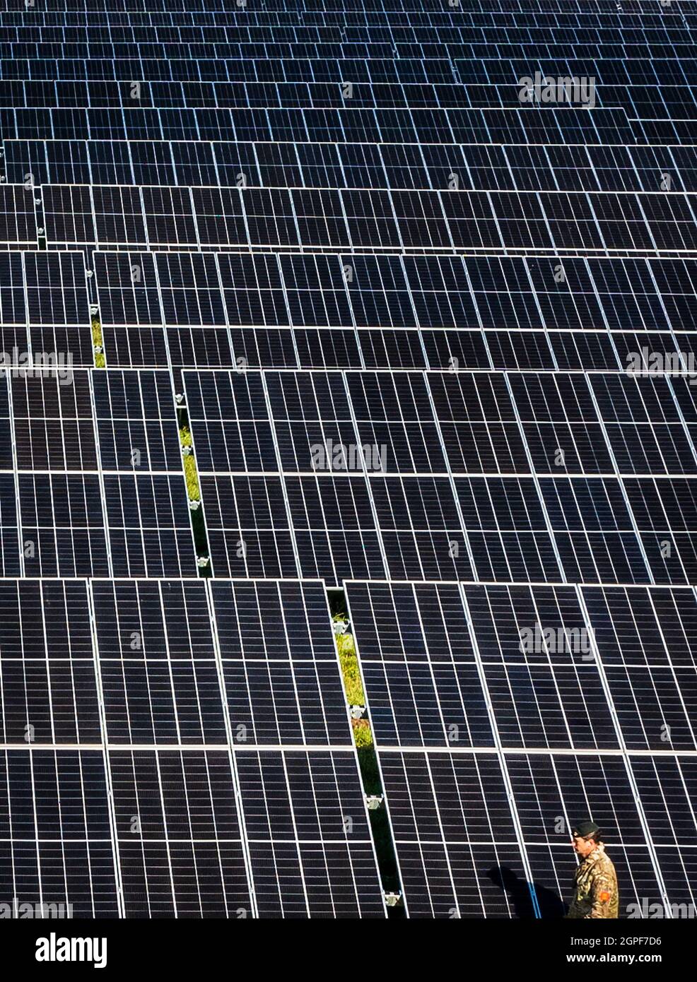 Major David Owen walks through a field of solar panels at the opening ...