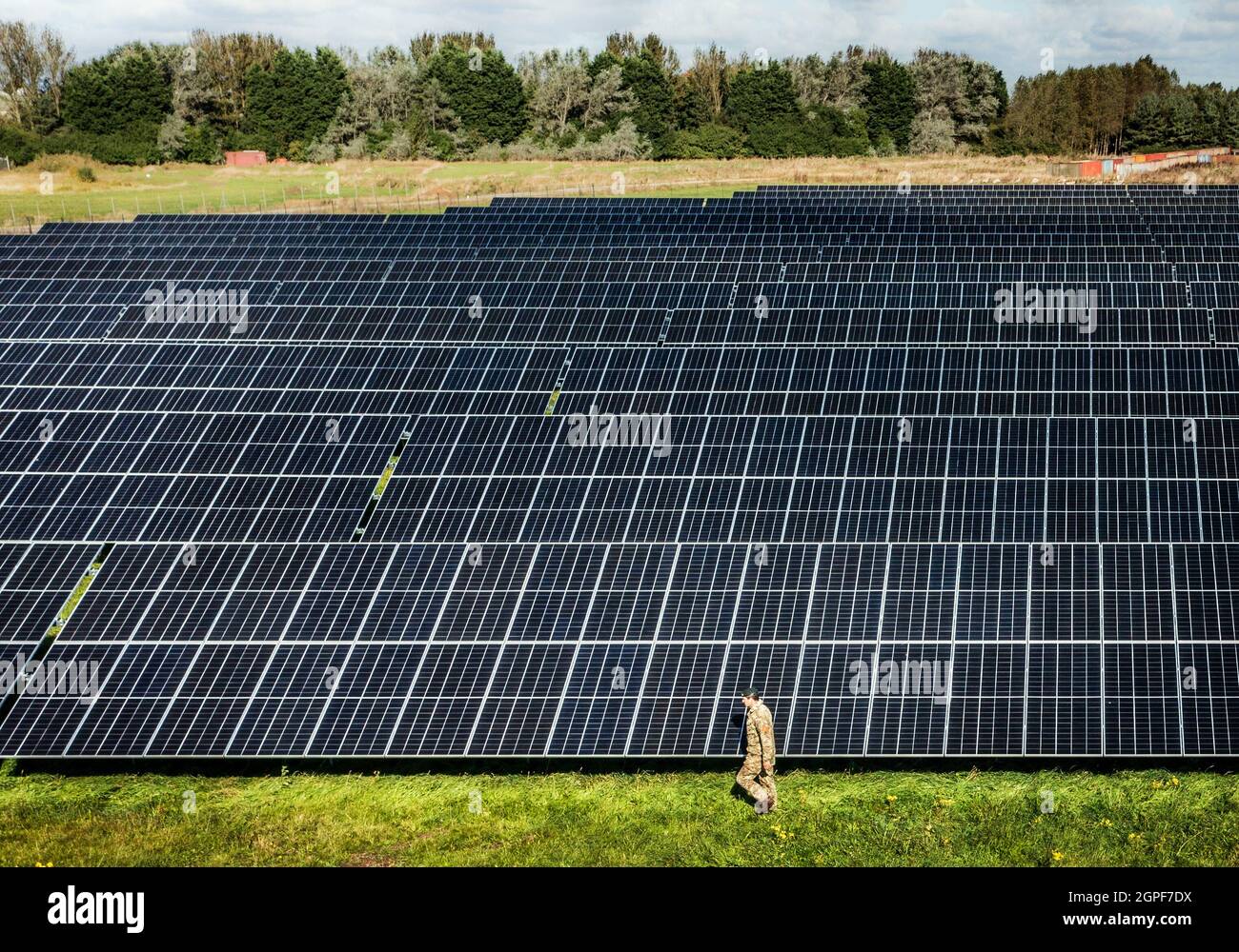 Major David Owen walks through a field of solar panels at the opening ...