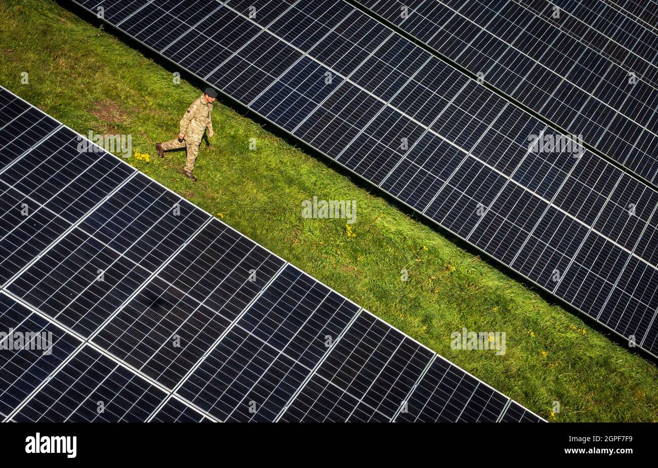 Major David Owen walks through a field of solar panels at the opening ...