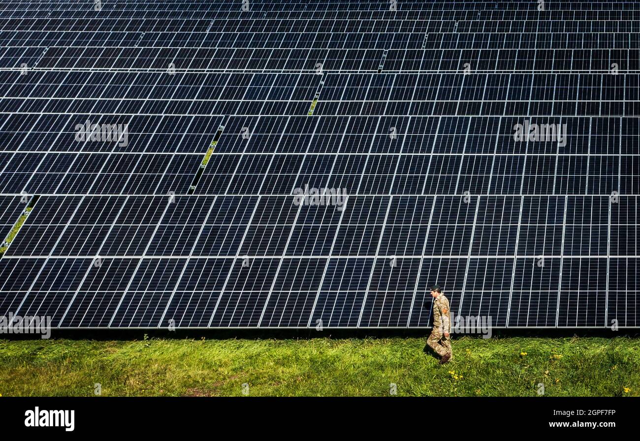 Major David Owen walks through a field of solar panels at the opening ...