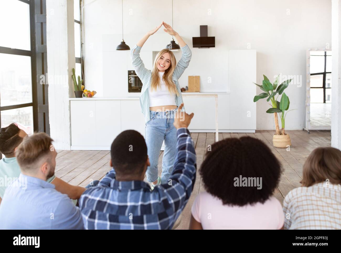 Group of millennial diverse friends playing charades at home Stock ...