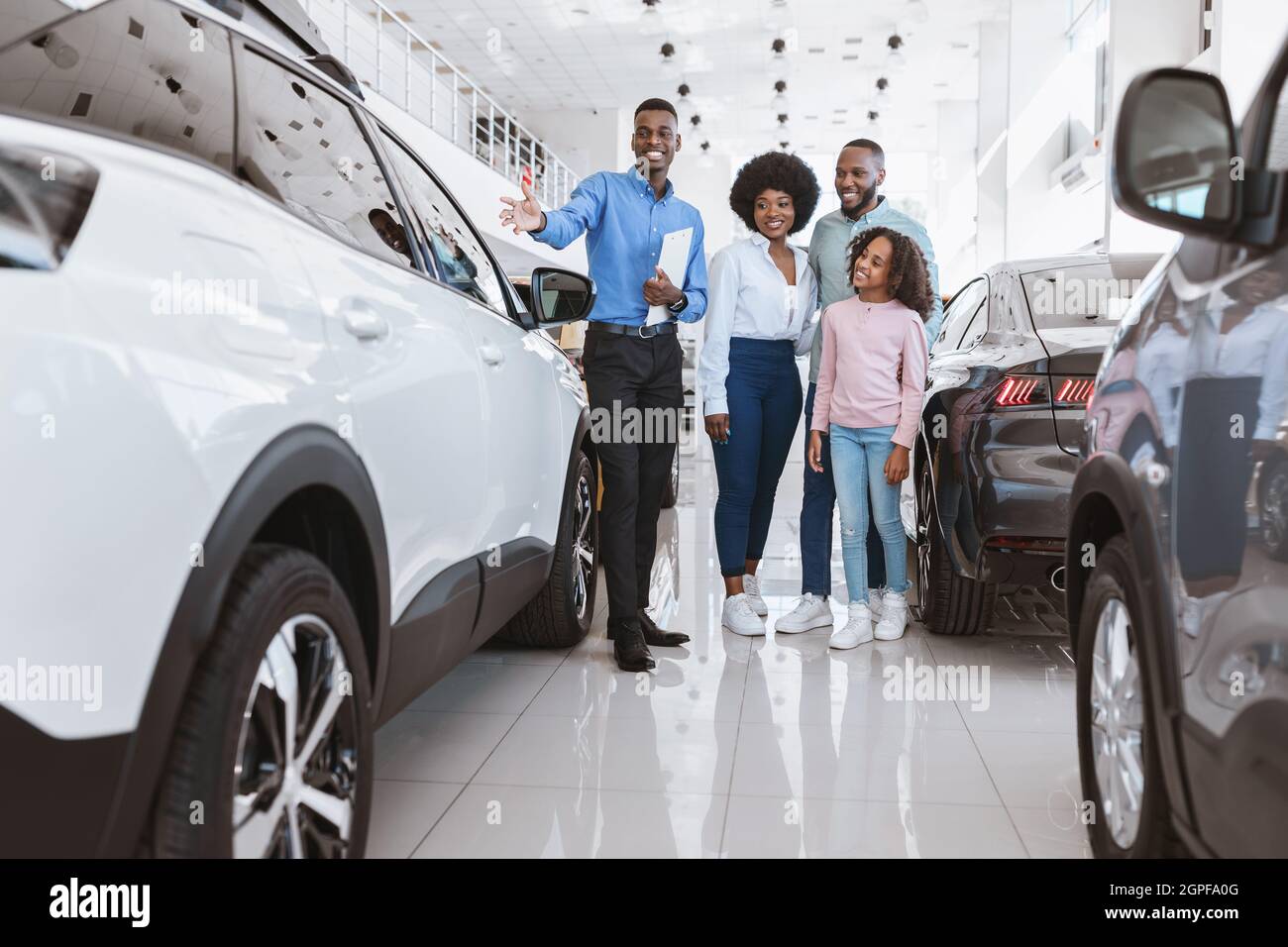 Car selling business. African American family consulting with salesman ...