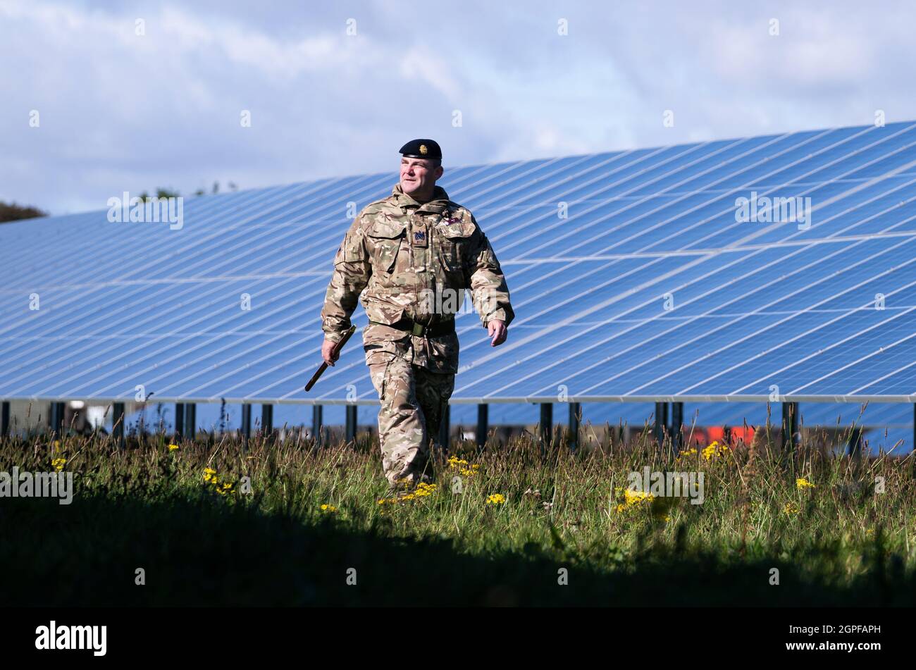 Sergeant Major Jimmy Girvan walks through a field of solar panels at ...