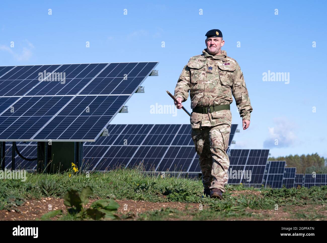 Sergeant Major Jimmy Girvan walks through a field of solar panels at ...