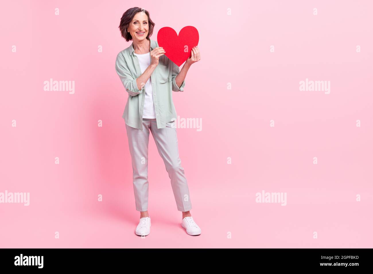 Full length portrait of charming positive person hold large heart card ...