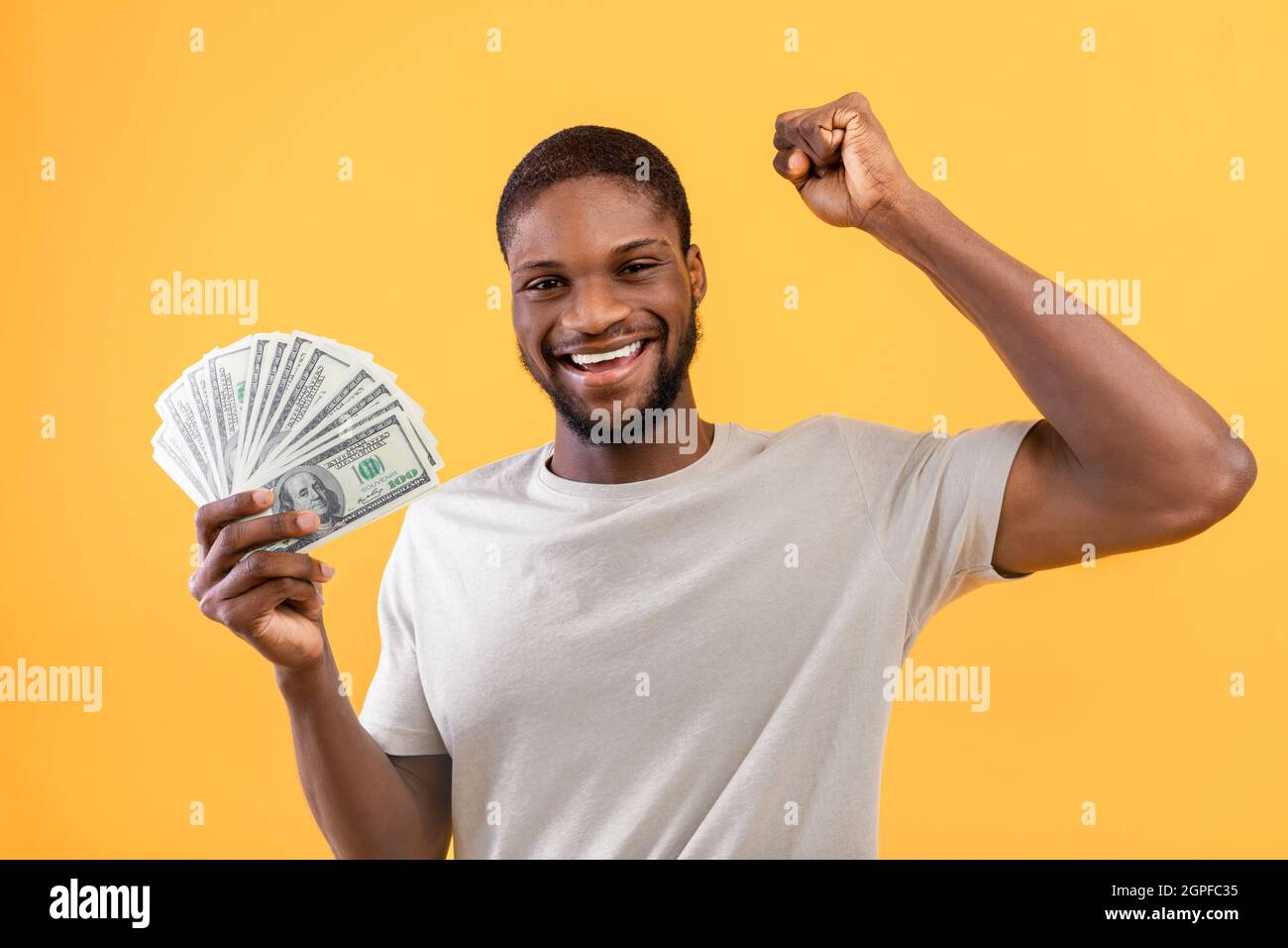 Omg, I'm rich. Overjoyed black man holding money cash and looking at ...