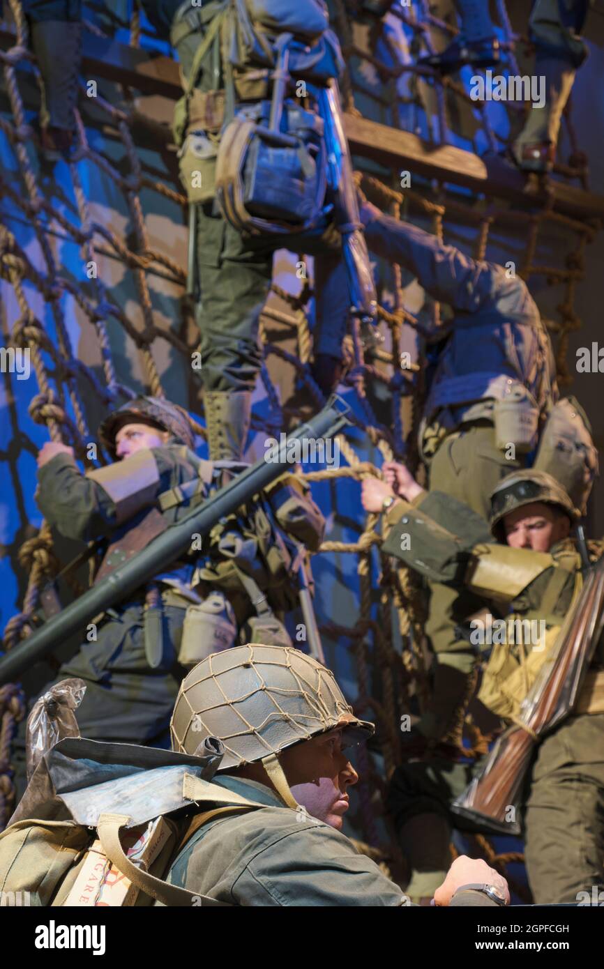 Soldiers climbing down a rope ladder onto a Higgins landing craft ...