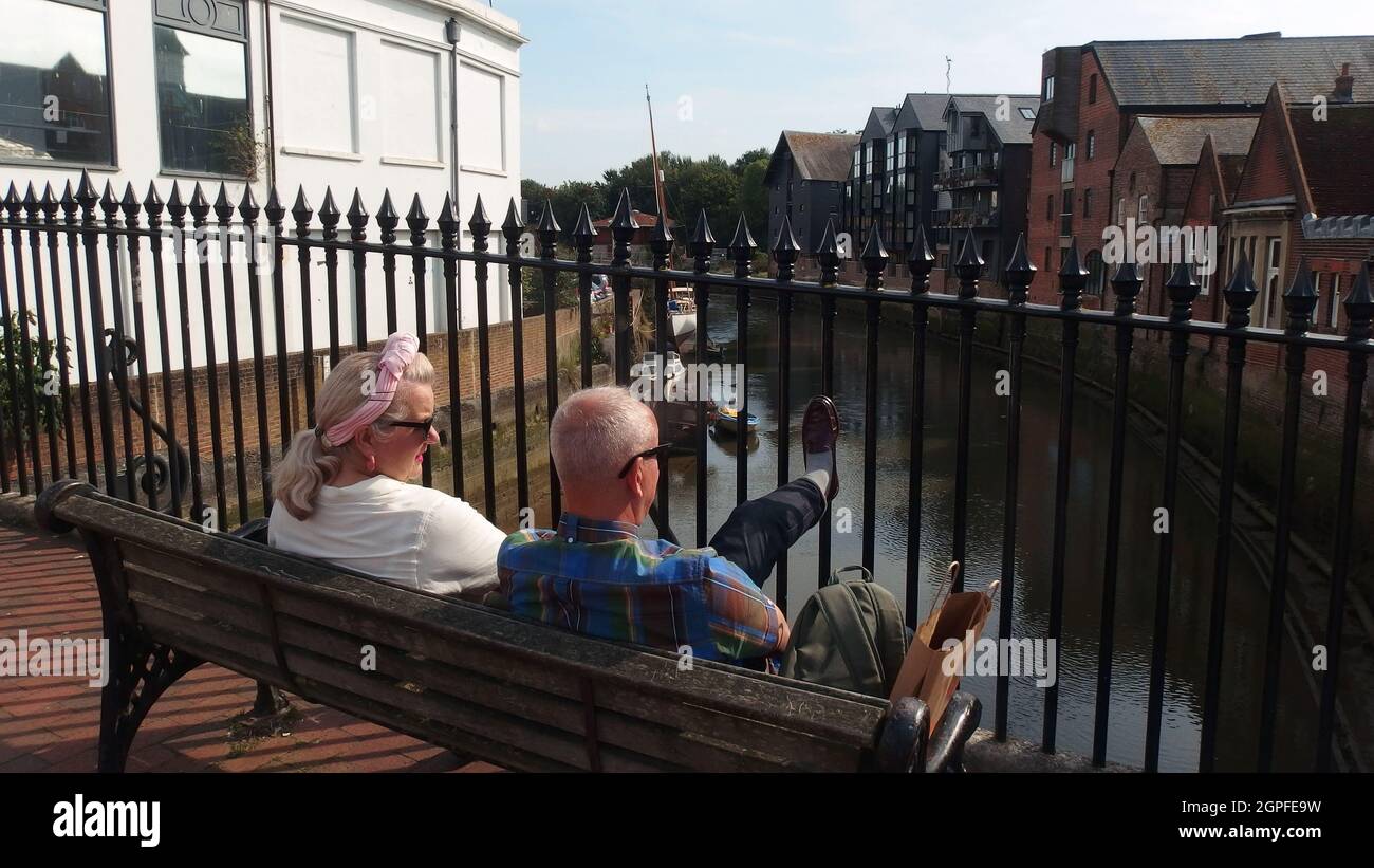 A couple seated by the bridge over the River Ouse in Cliffe High Street ...