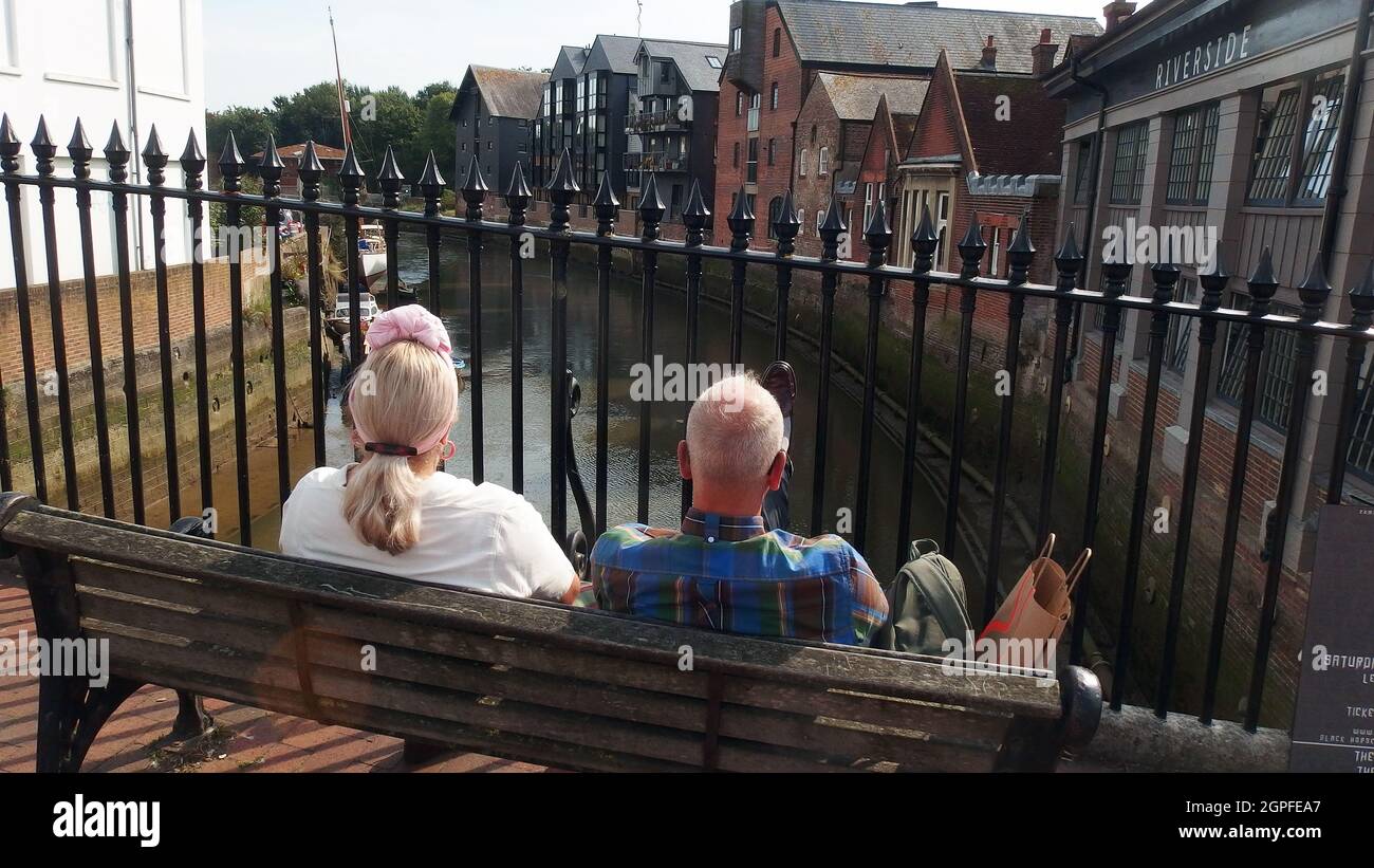 A couple seated by the bridge over the River Ouse in Cliffe High Street ...