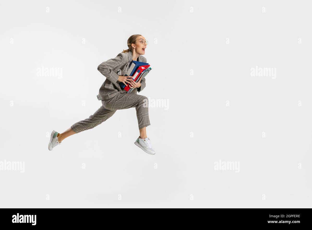 Full-length portrait of woman, office worker running with folders ...