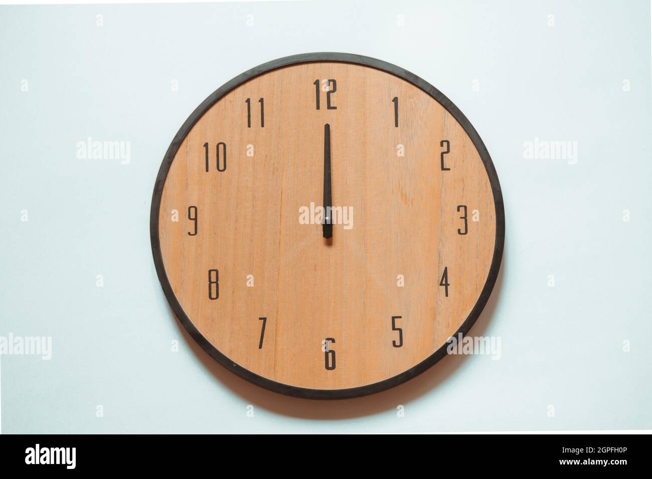 Wooden mechanical wall clock showing twelve o'clock Stock Photo - Alamy