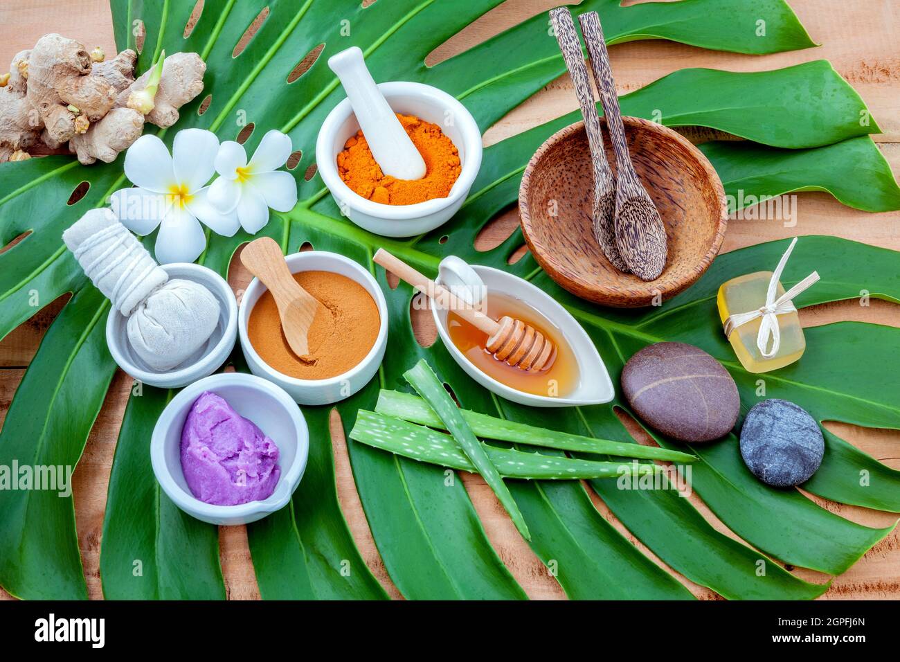 Green leaves with nature spa ingredient turmeric powder in white mortar ...