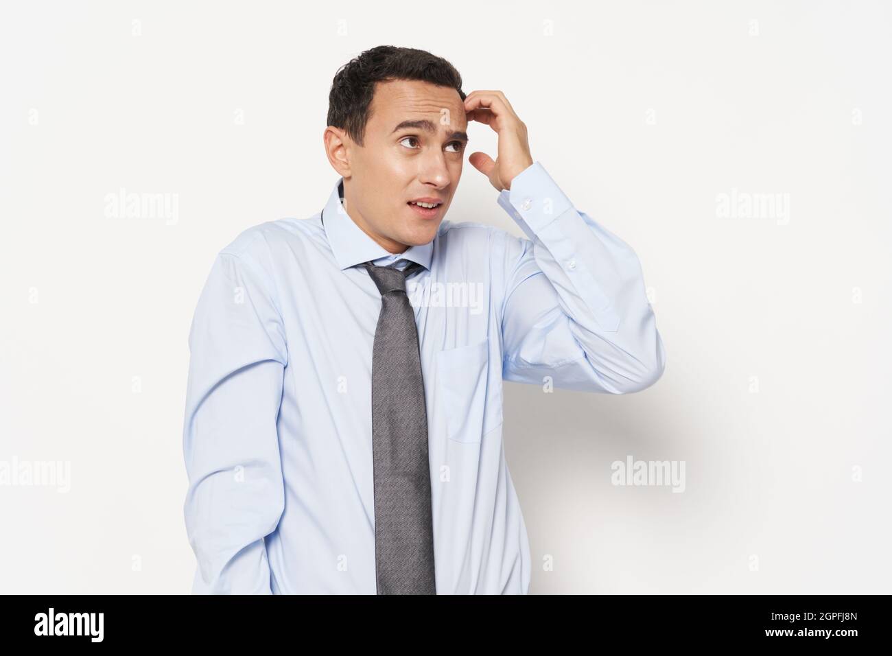 indignant man touches his head with his hand and light shirt tie model ...