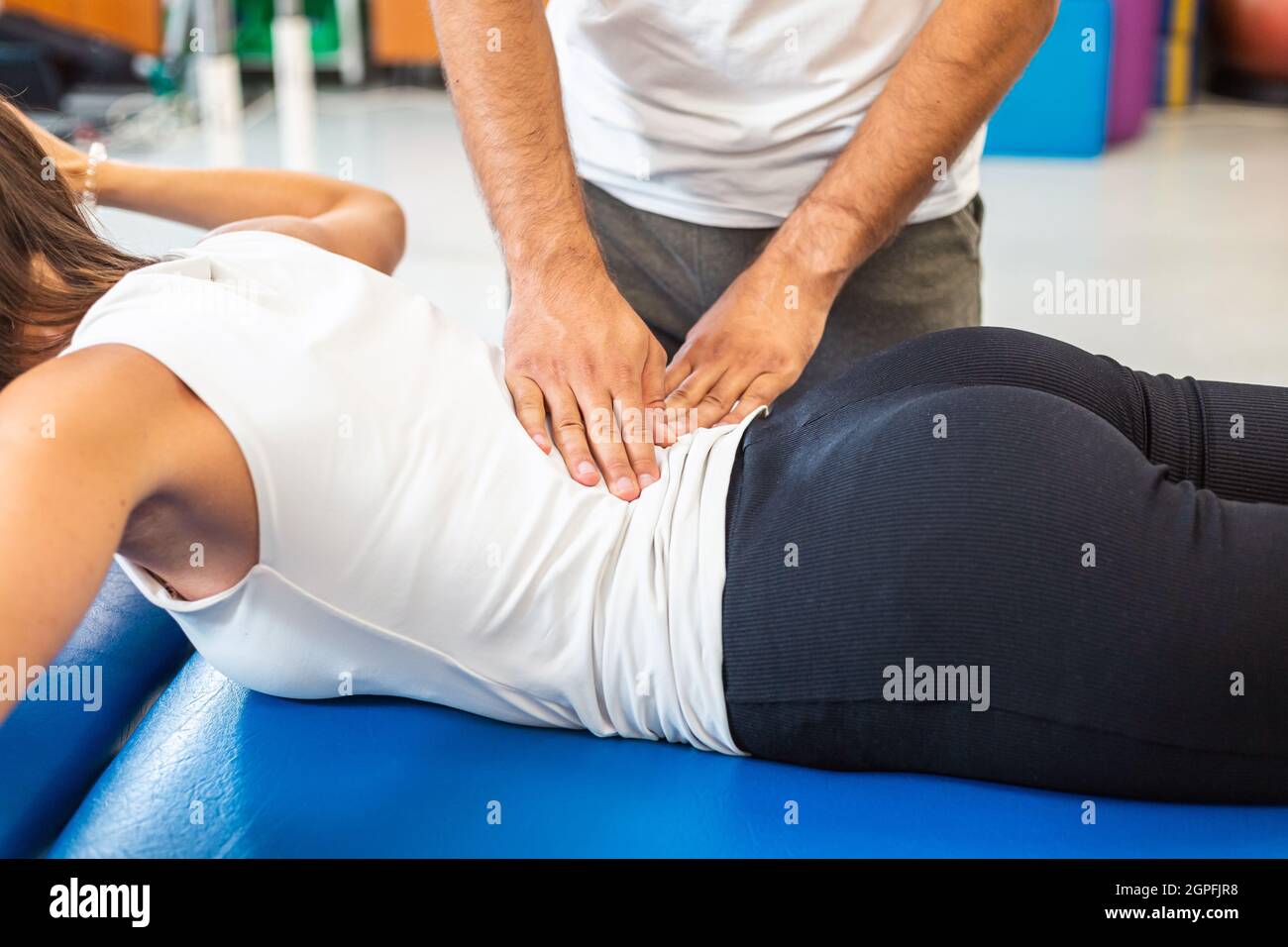 Physiotherapist hands pressing female patient low back Stock Photo - Alamy