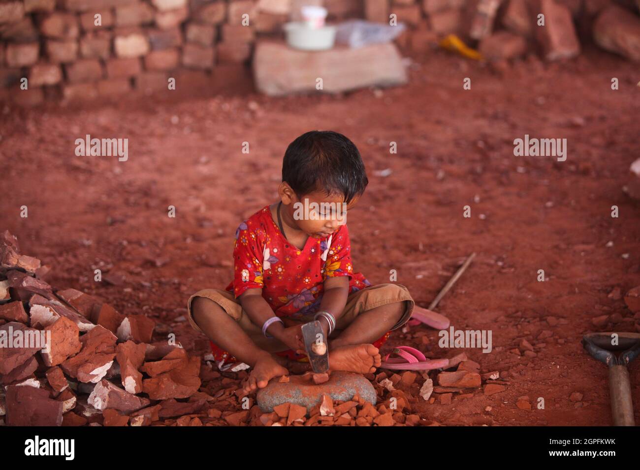 A Bangladeshi child labor breaking brick in a brick break yard inside ...