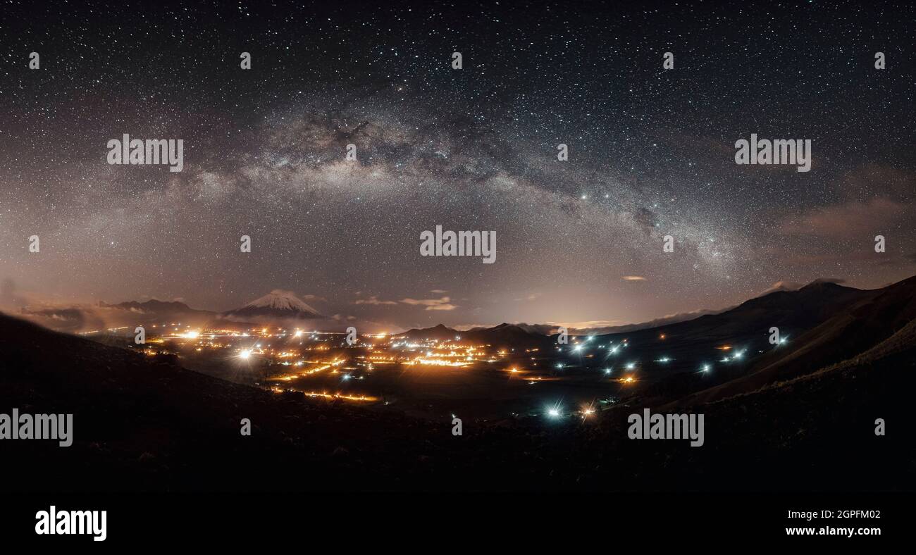 The milky way cover a little town in mountains with the star lights ...