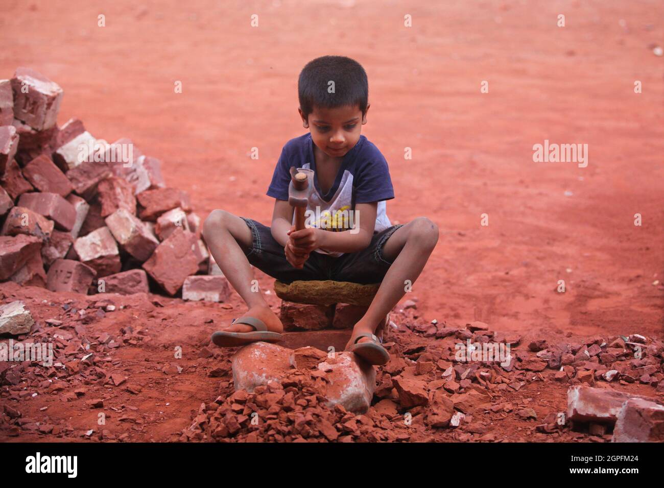 A Bangladeshi child labor breaking brick in a brick break yard inside ...