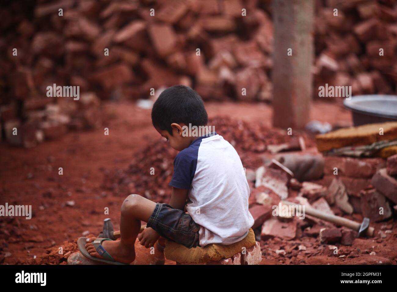 A Bangladeshi child labor breaking brick in a brick break yard inside ...