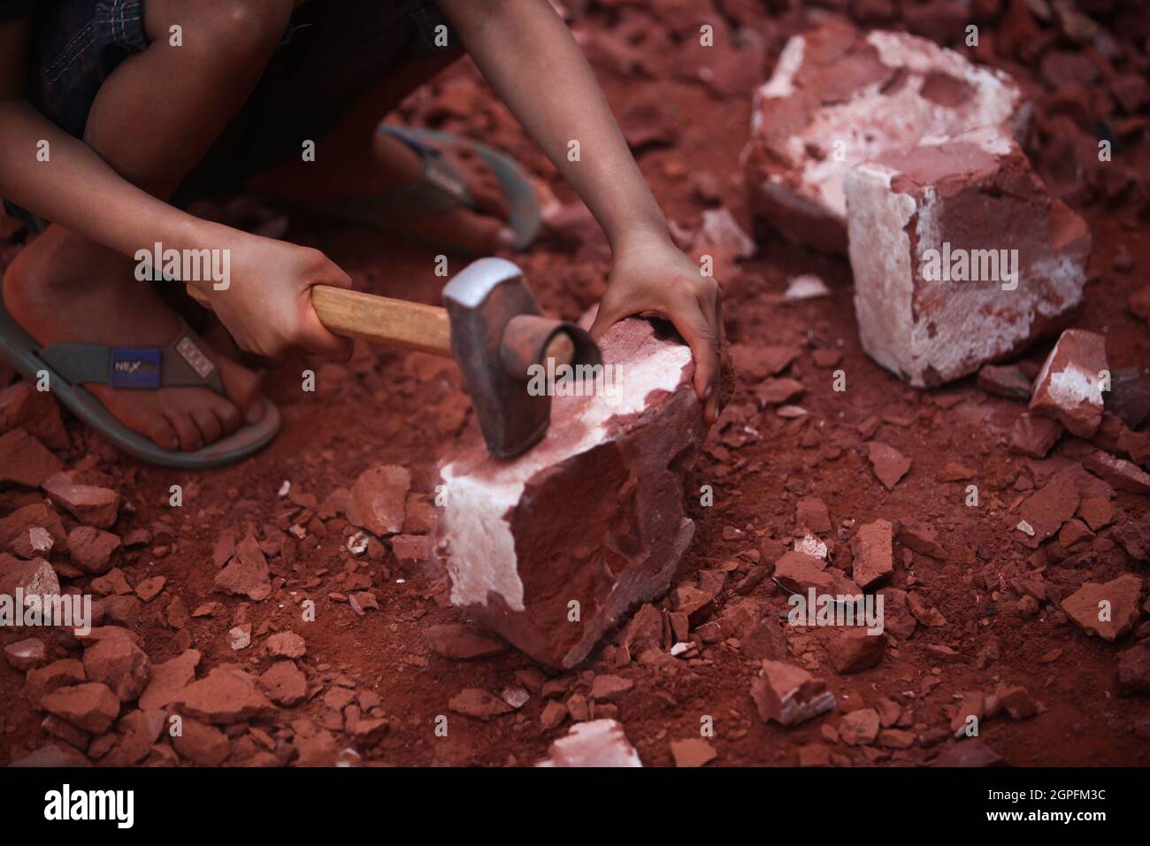 A Bangladeshi child labor breaking brick in a brick break yard inside ...