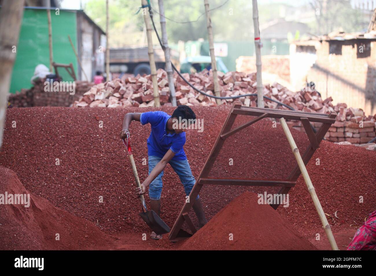A Bangladeshi child labor breaking brick in a brick break yard inside ...
