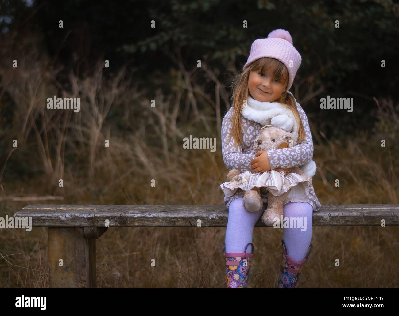 Little cute child sitting on a bench Stock Photo - Alamy
