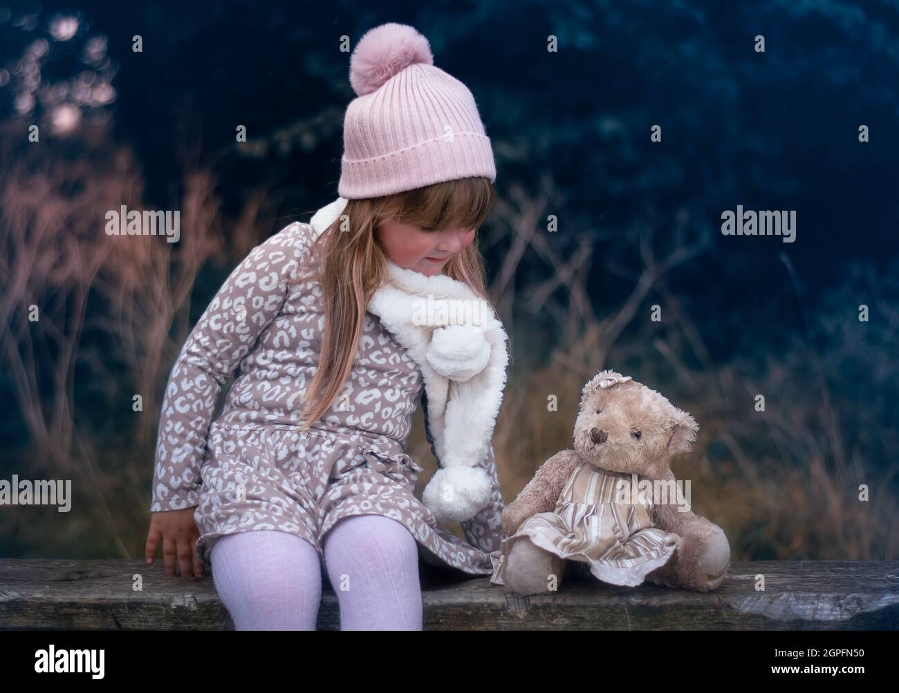 Little cute child sitting on a bench Stock Photo - Alamy