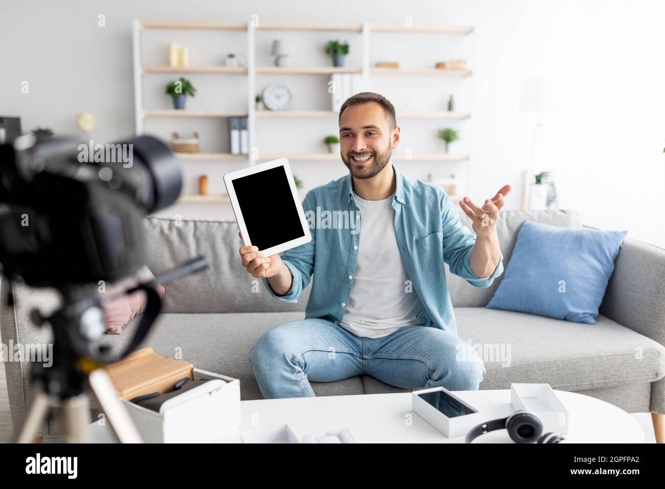 Happy male influencer filming video review of modern digital tablet on ...