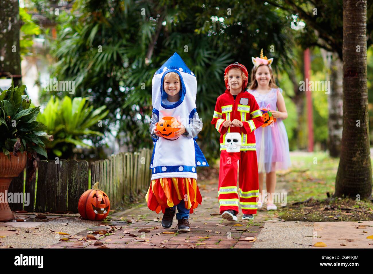 Kids trick or treat in Halloween costume. Children in colorful dress up ...