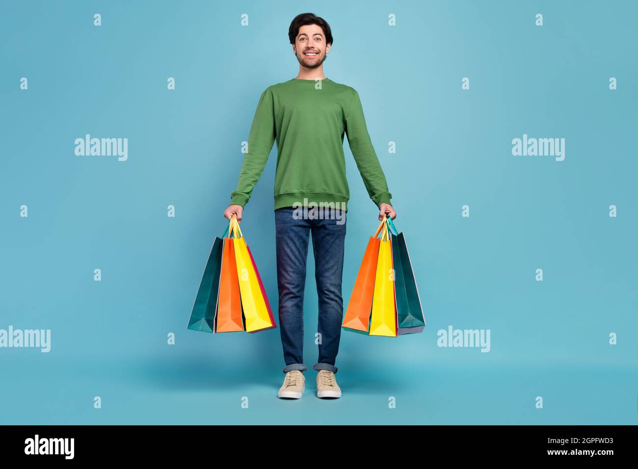 Full body photo of good looking smiling male hold shopping bags ...