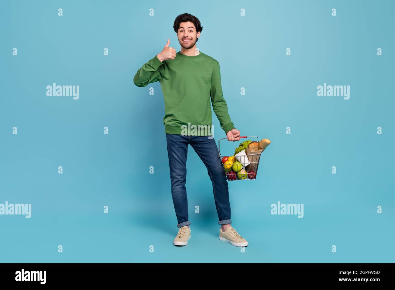 Full size photo of young smiling male go shopping buy groceries showing ...