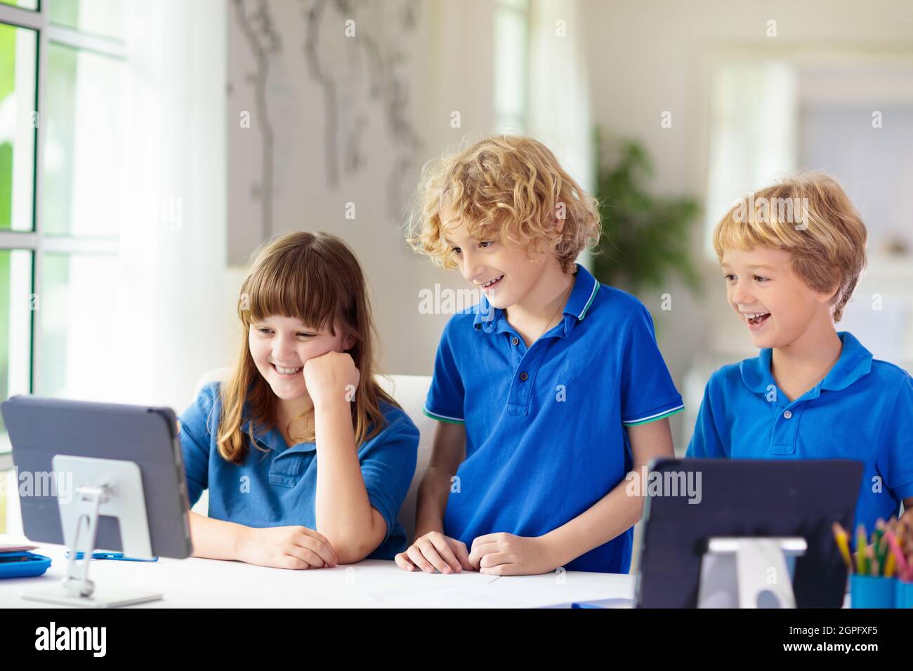 Online remote learning. School kids with computer having video ...