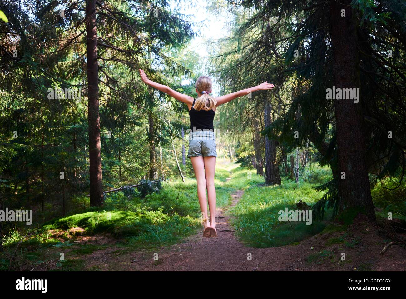 Young girl flying in the air in the woods. Jumping for freedom Stock ...