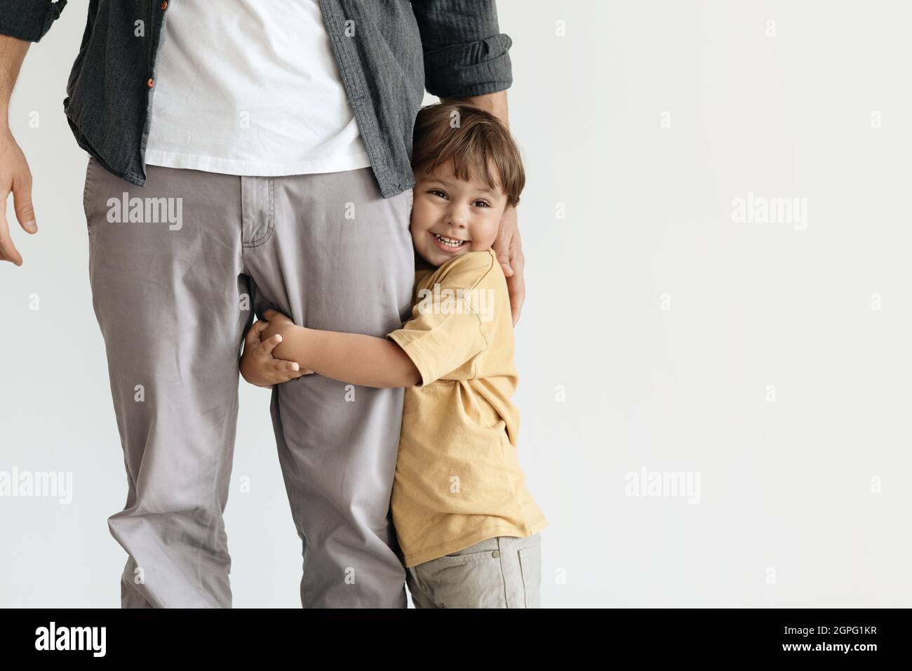 Sincere kid affection. Emotional little son embracing strongly his ...