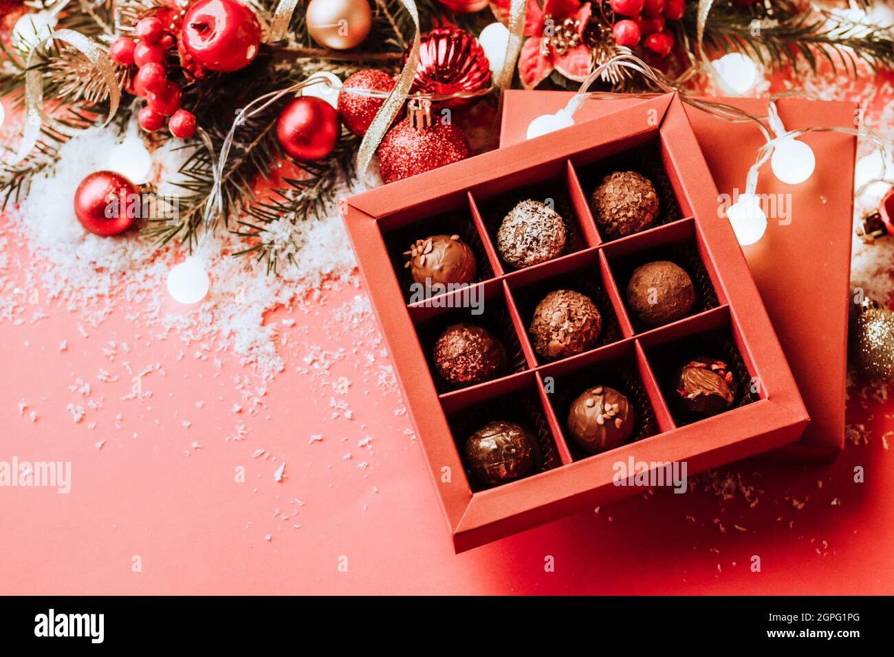 Chocolates in a red festive box dark chocolate truffle on a Christmas ...