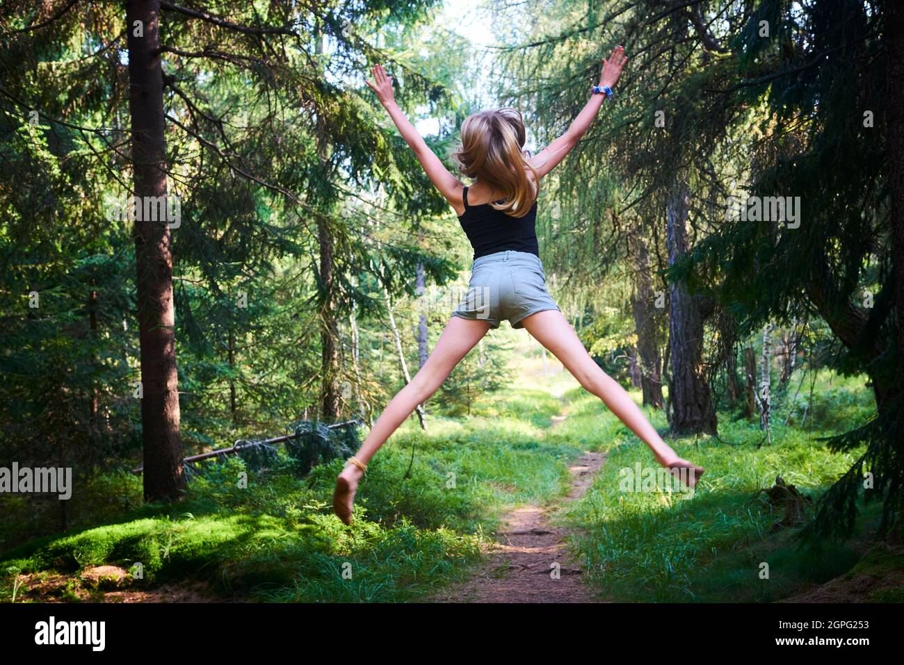 Young girl flying in the air in the woods. Jumping for freedom Stock ...