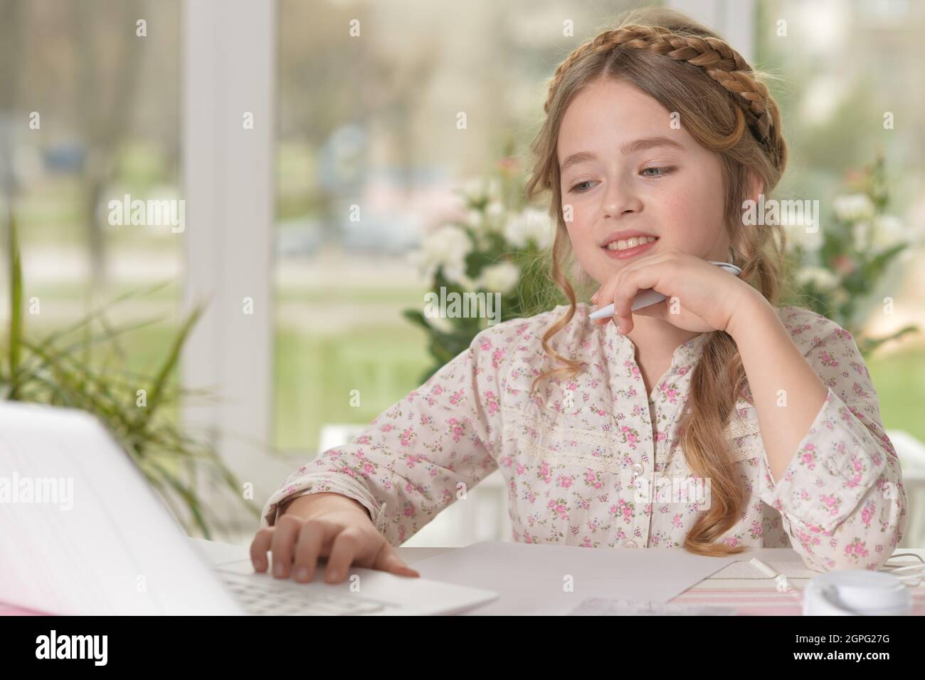 Cute little girl using laptop at home Stock Photo - Alamy