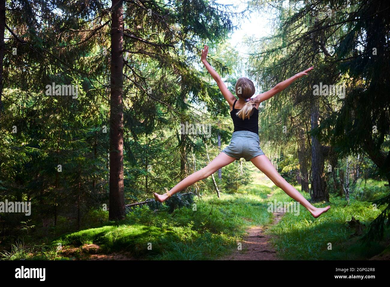 Young girl flying in the air in the woods. Jumping for freedom Stock ...