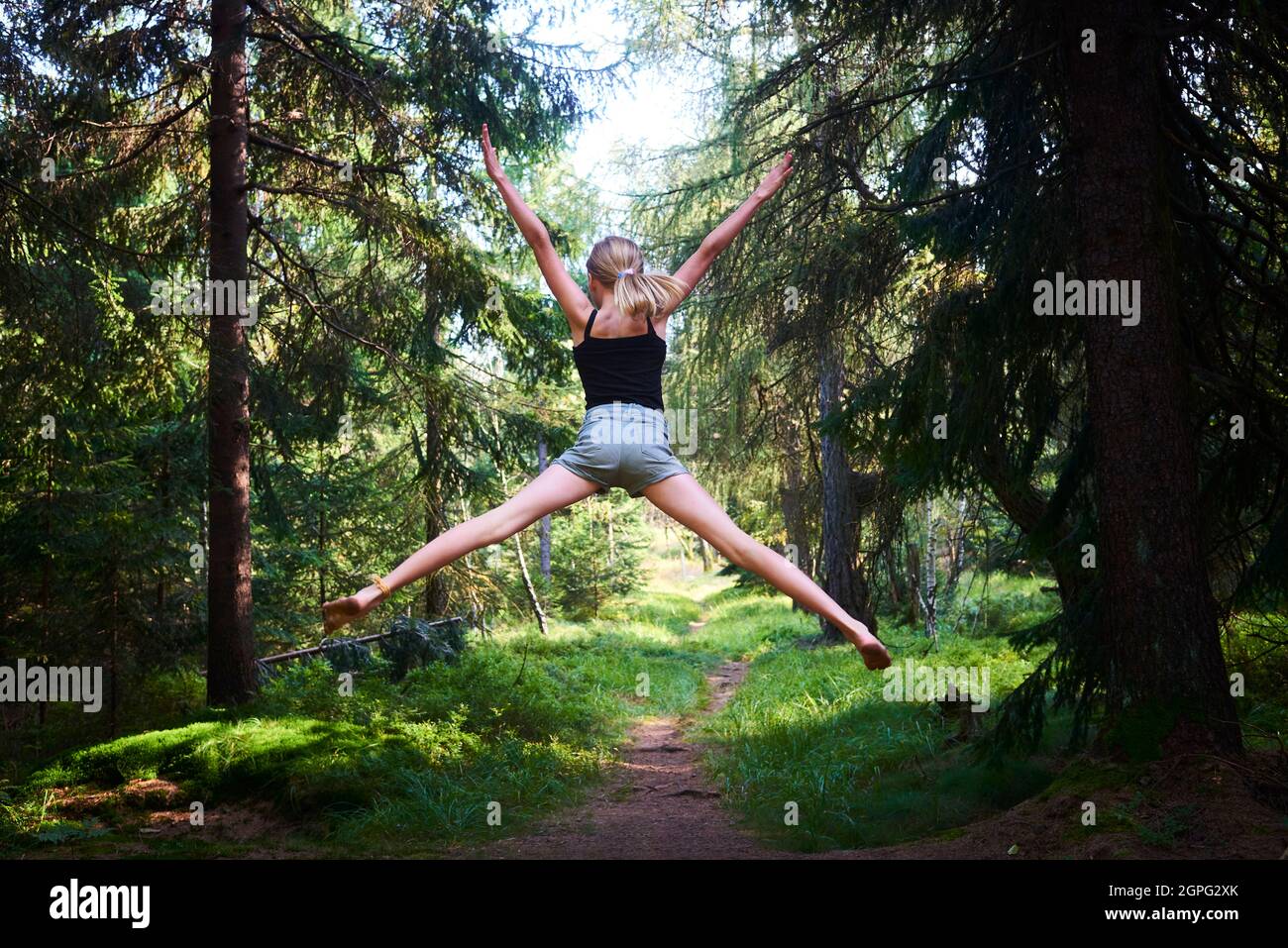 Young girl flying in the air in the woods. Jumping for freedom Stock ...