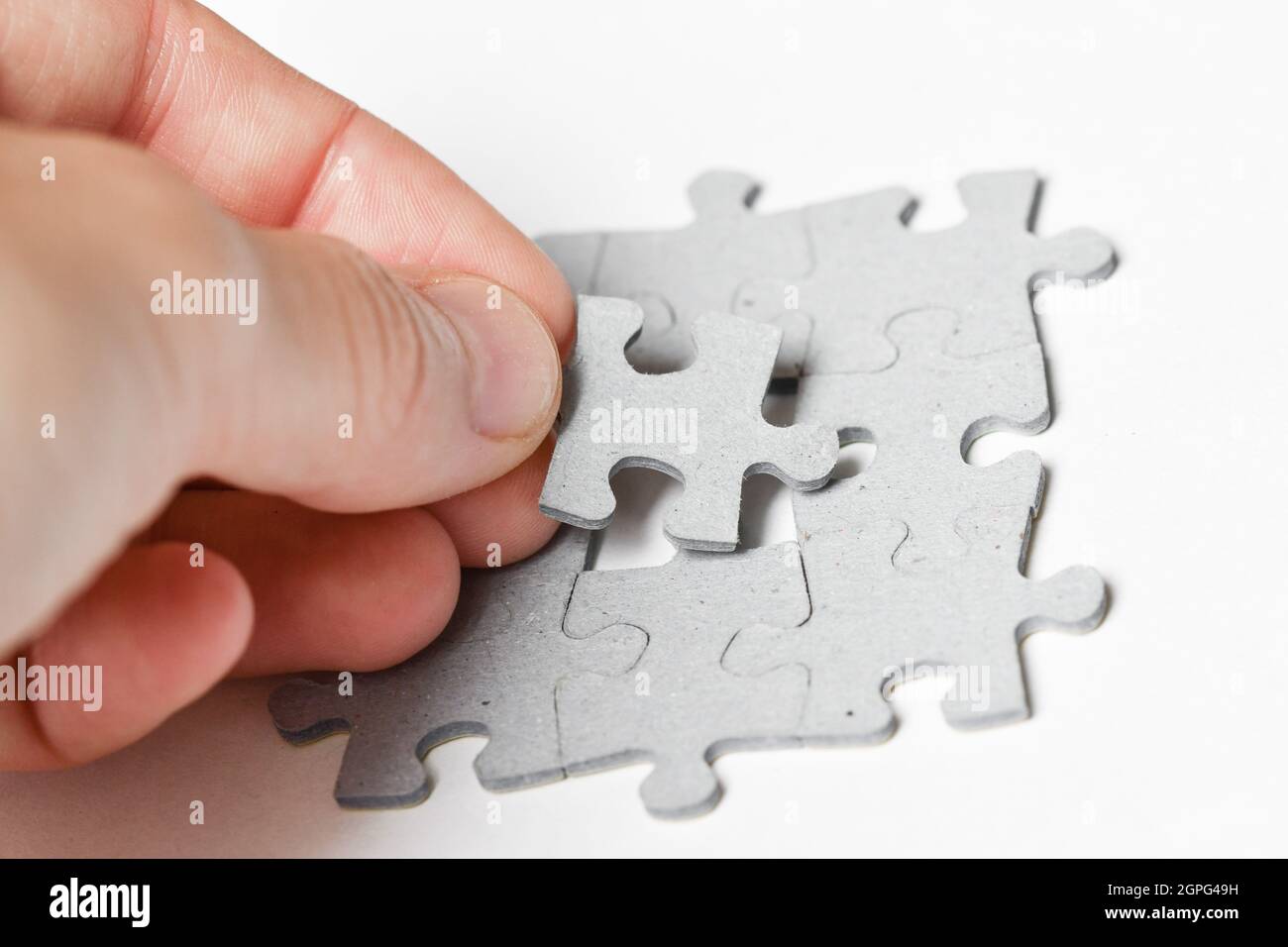 Photo of a person adding last piece of jigsaw puzzle to fit together on ...