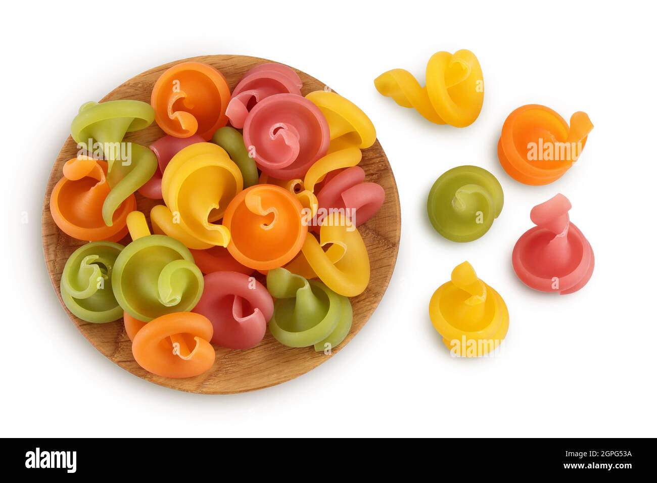 Raw colored pasta in wooden bowl isolated on white background with ...