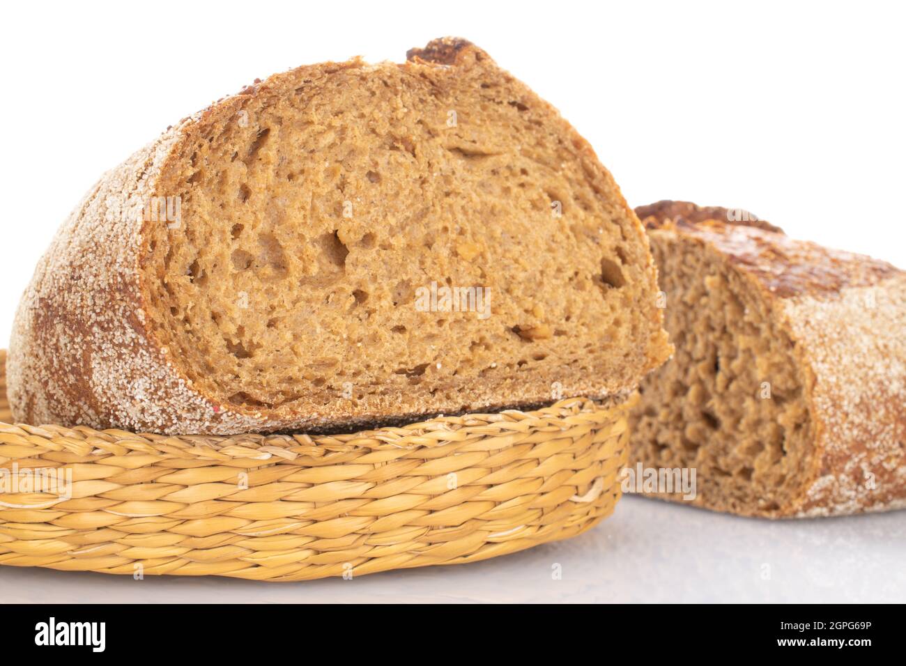 Two halves of a loaf of flavored buckwheat bread with a straw plate ...