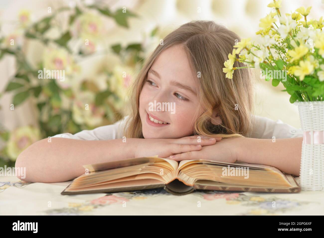 Portrait of young girl reading interesting big book Stock Photo - Alamy